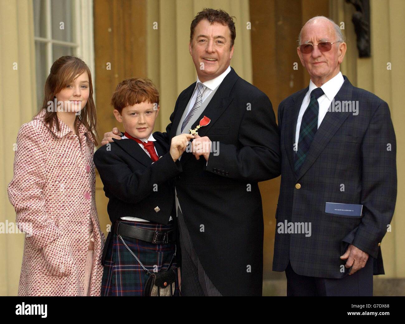 John Boyle (centre) at Buckingham Palace, after collecting his MBE for ...