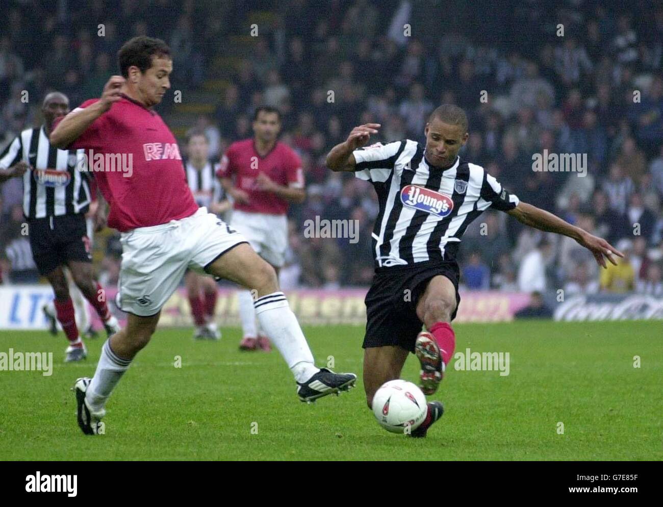Swansea's Scott Fitzgerald (left) challenges Grimsby's Justin Whittle ...