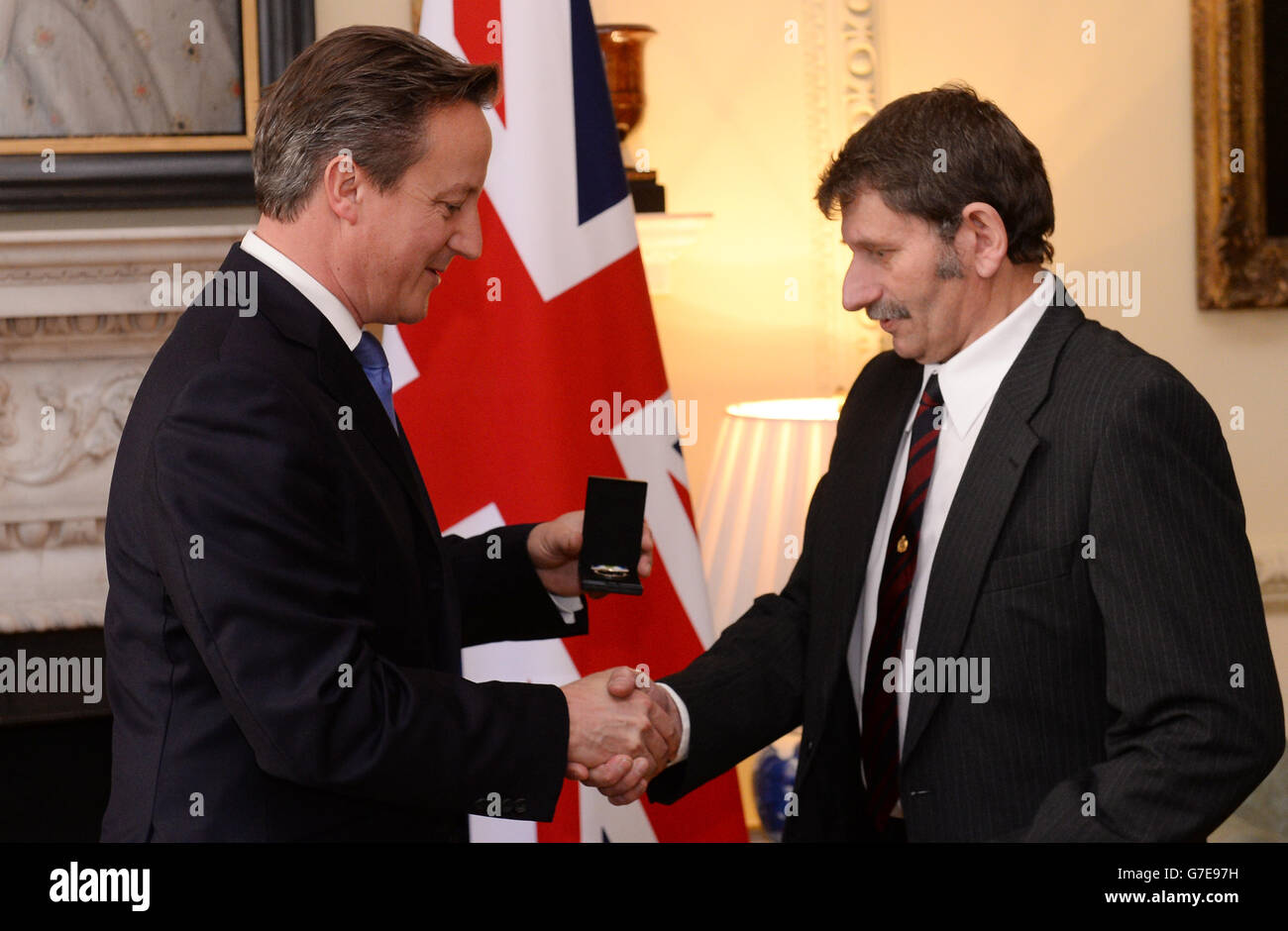 Prime Minister David Cameron (left) presents Terence Budd with his ...