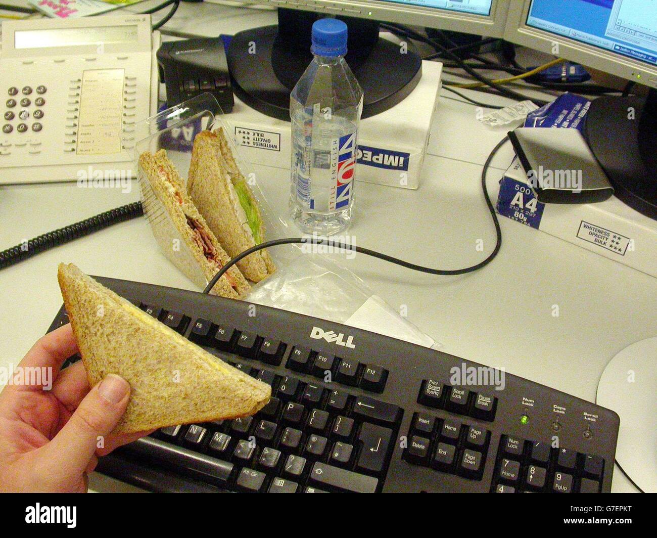 A worker eating at their desk Stock Photo - Alamy