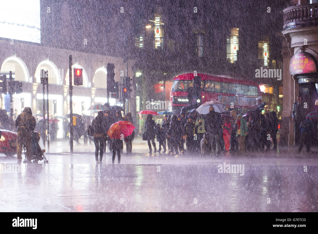 Heavy rain sweeps over Piccadilly Circus in London Stock Photo - Alamy