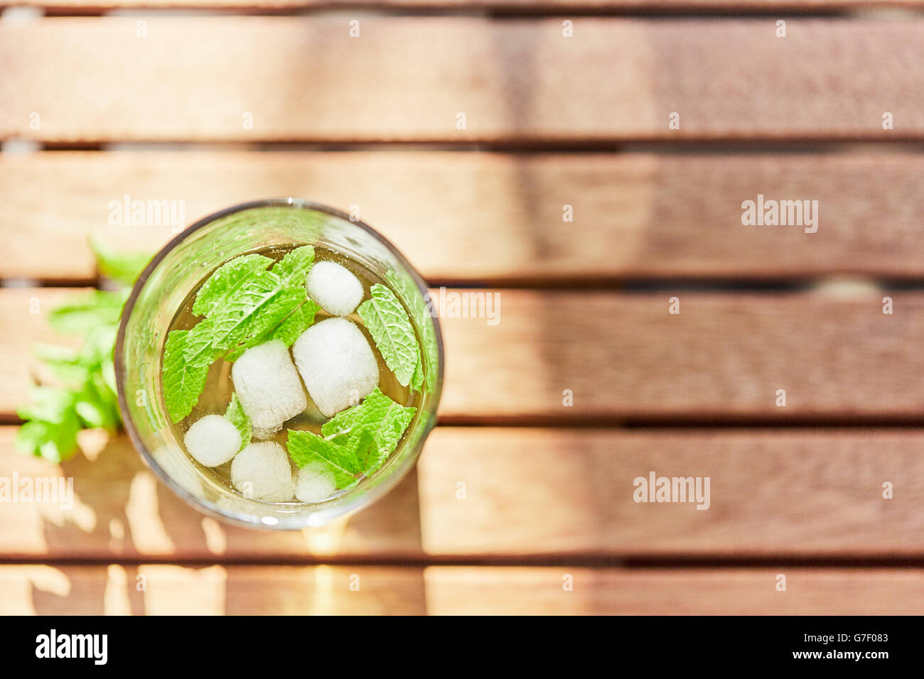 Cool drink with mint and ice in a glass on wooden table top view Stock ...