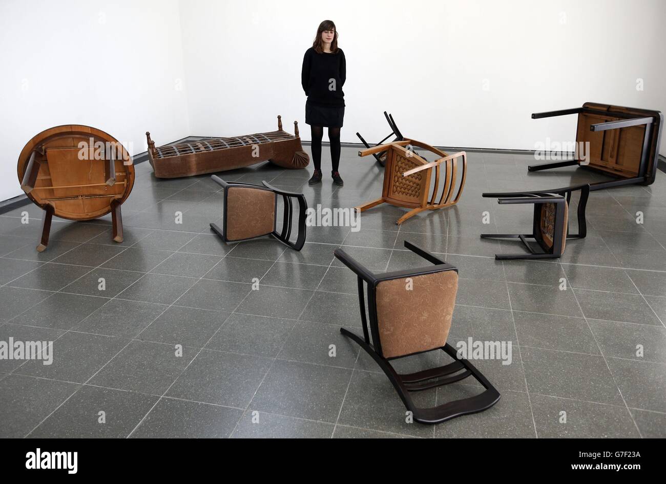 A gallery employee observes Reiner Ruthenbeck's work 'Overturned ...