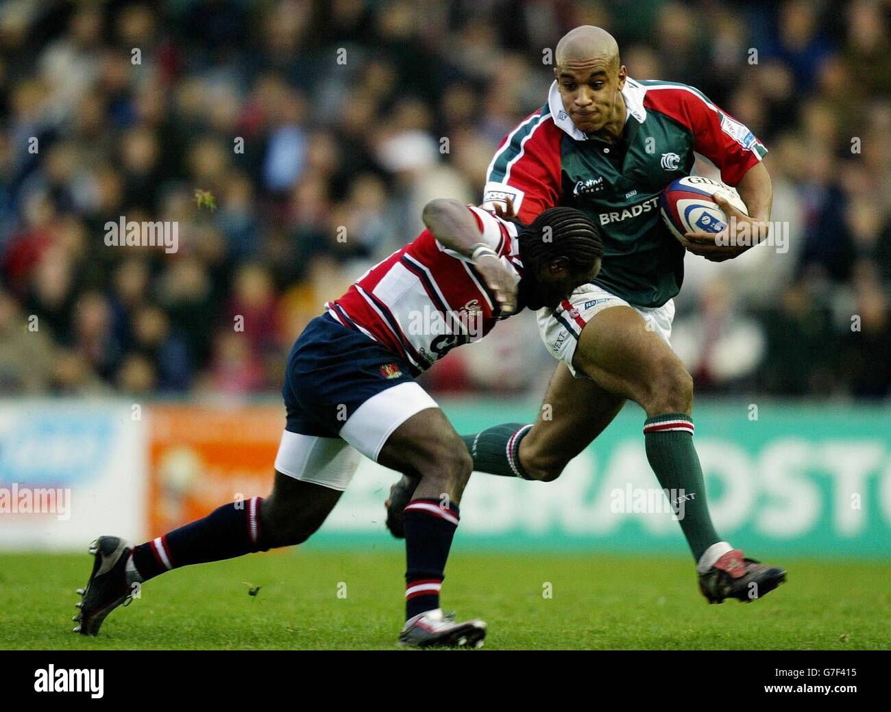 Leicester's Tom Varndell hands off the tackle of Gloucester's Marcel ...