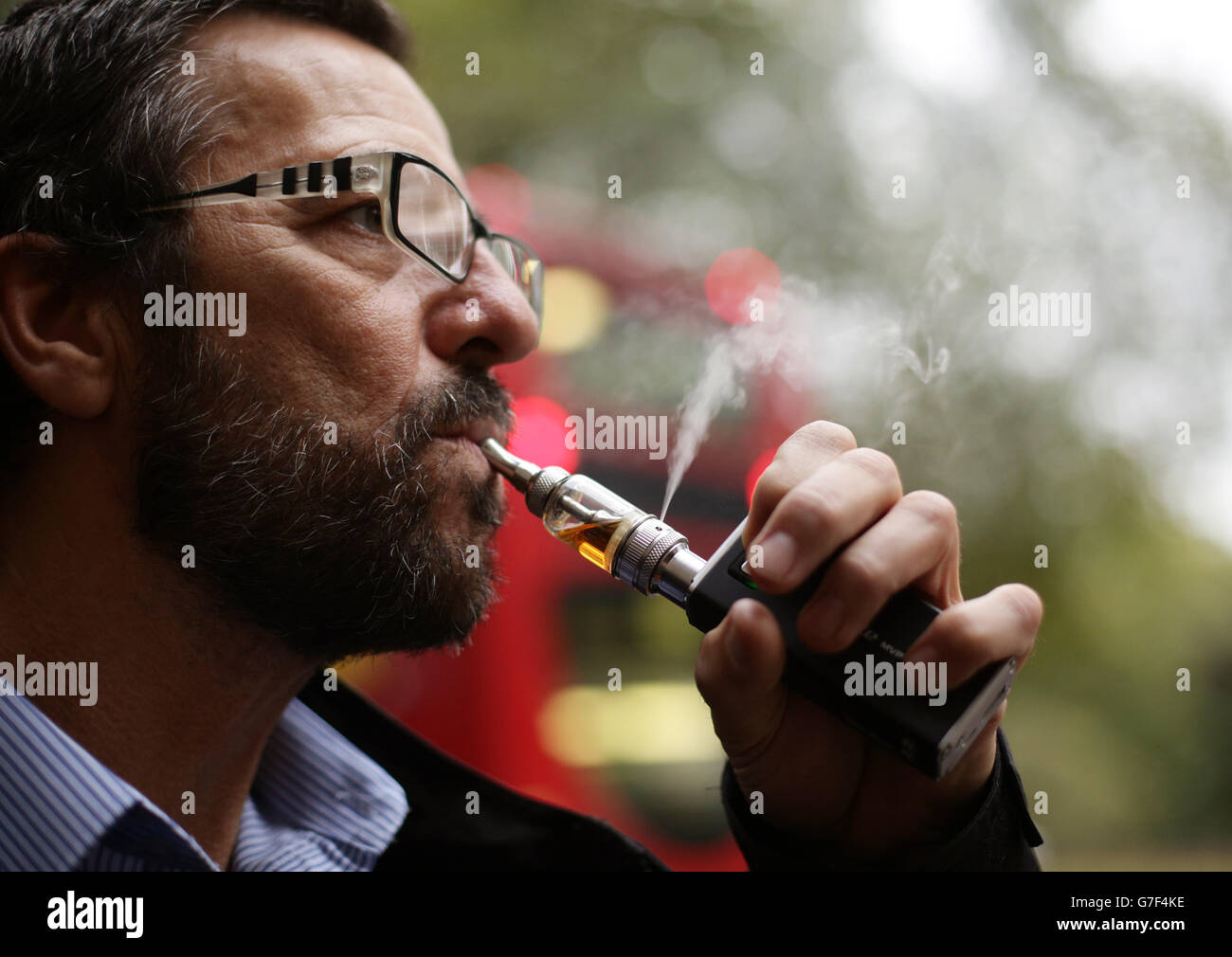 A man smoking an electronic cigarette (variously known as an e ...