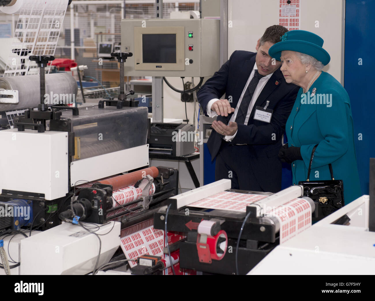 Queen Elizabeth II is shown stamp cutting and finishing machines by ...