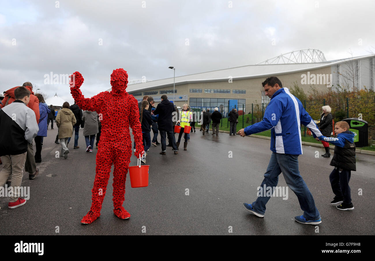 A man dressed in a full body poppy suit collects for the poppy appeal ...