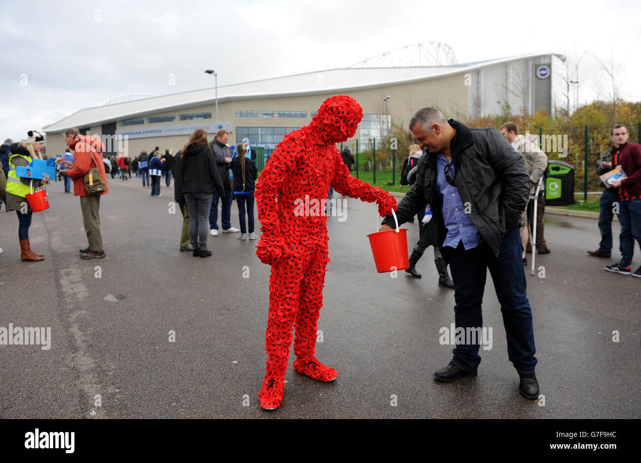 A man dressed in a full body poppy suit collects for the poppy appeal ...