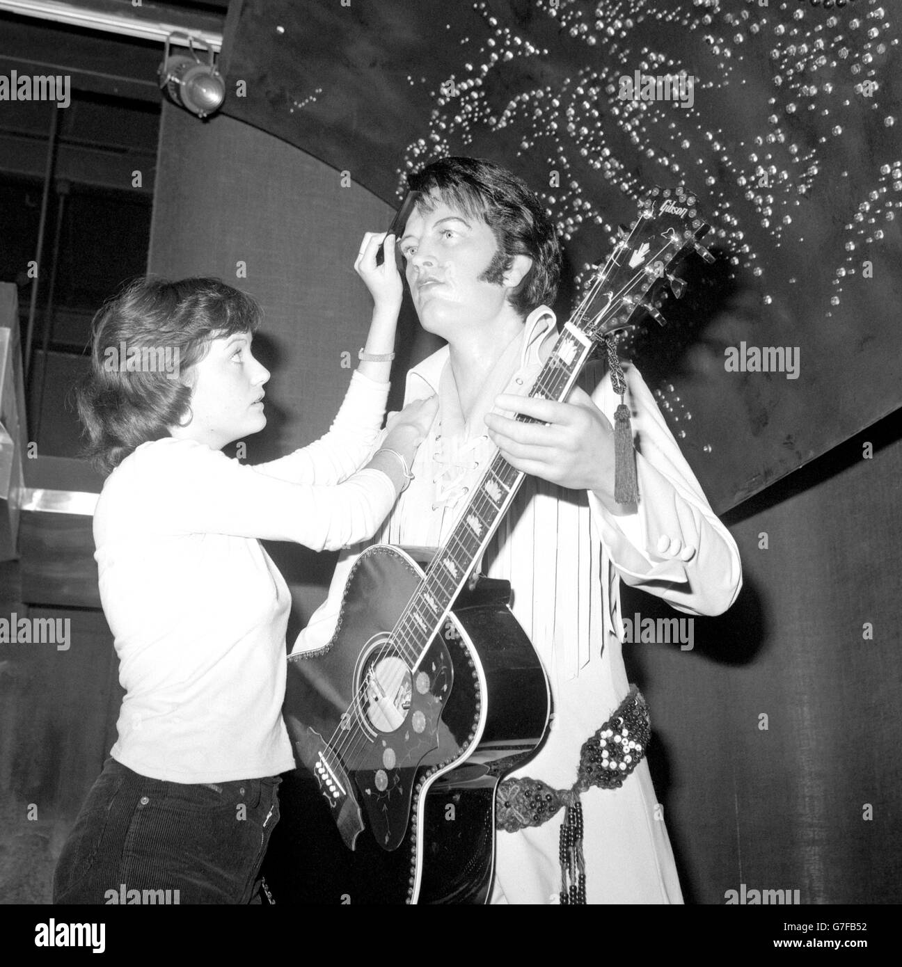 Carol Bell, 19, gives a final touch to the wax figure of Elvis Presley ...