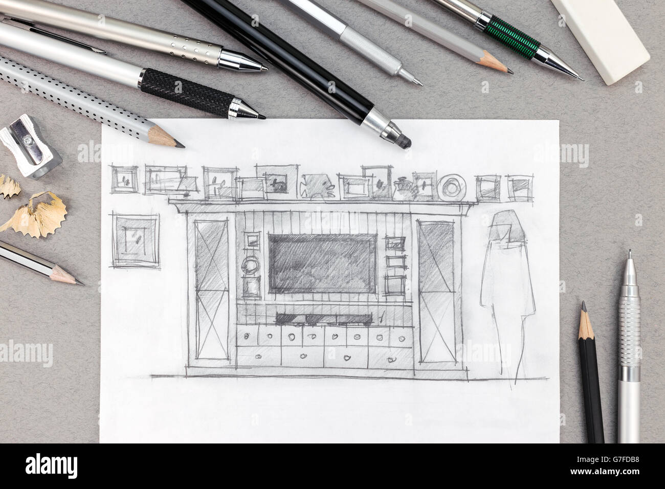 sketch of an entertainment wall with various drawing tools on gray desk ...