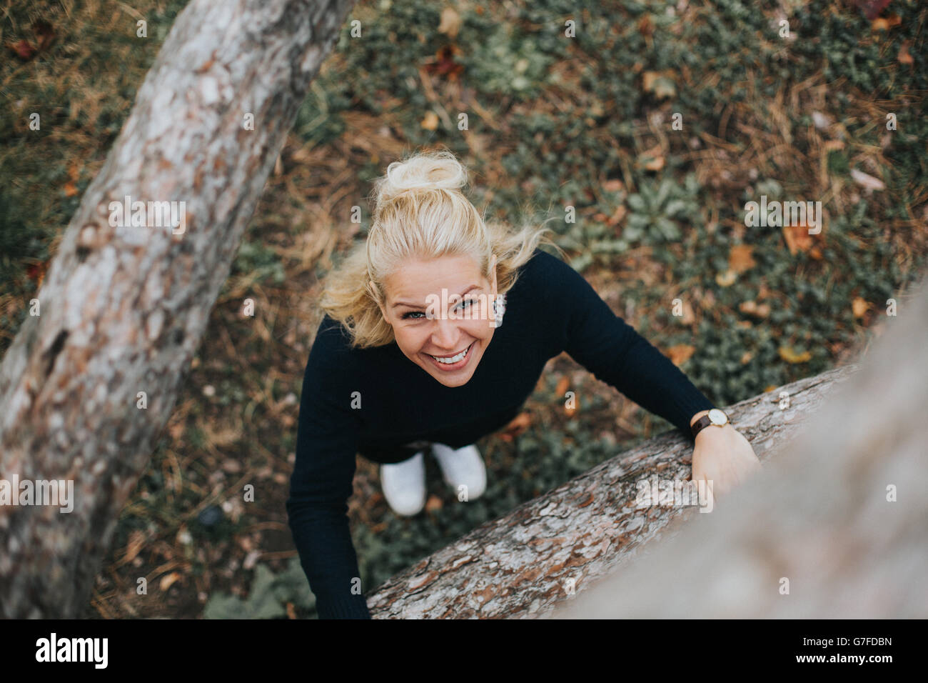 Blonde girl climbing trees Stock Photo - Alamy