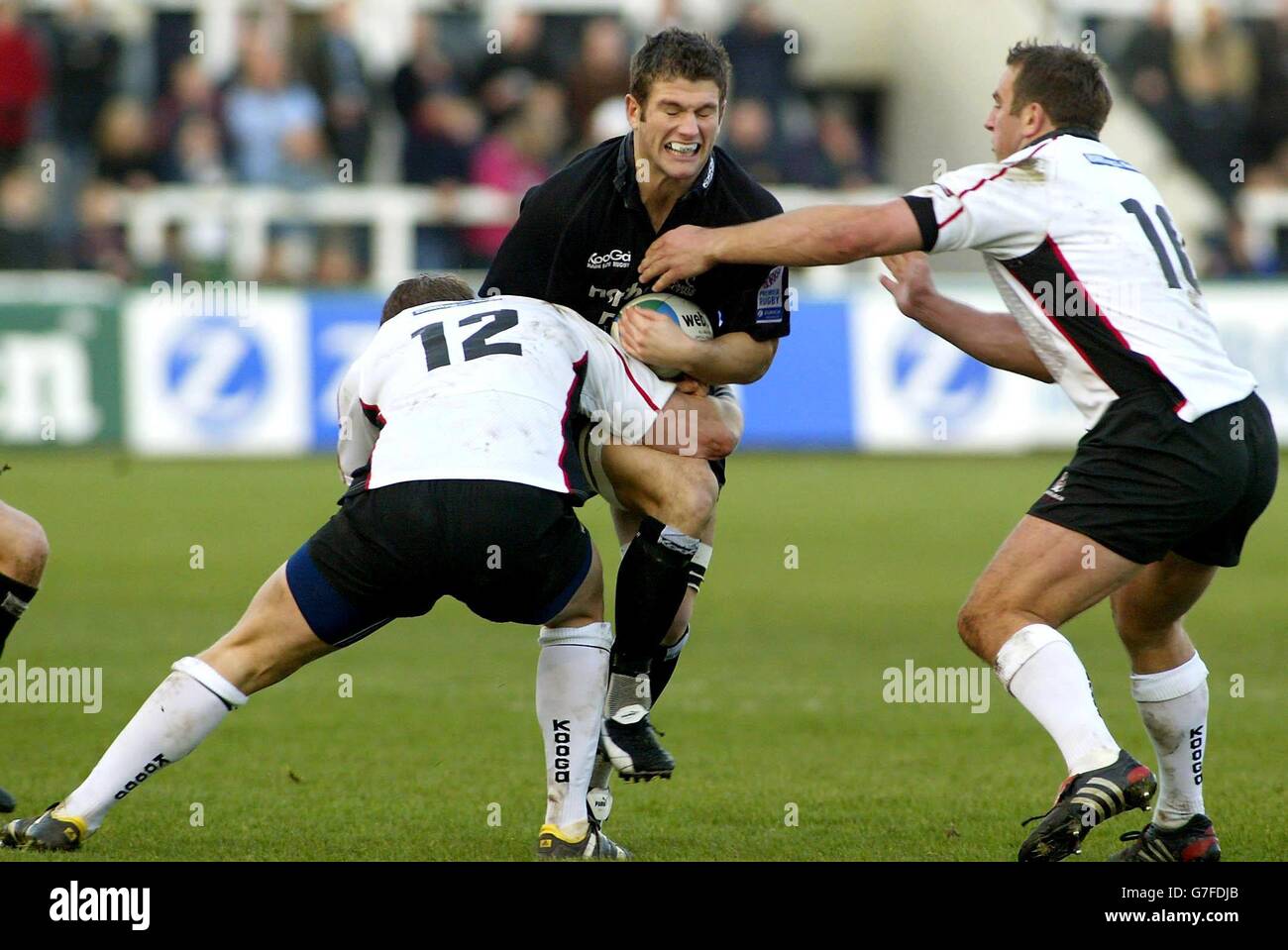 Newcastle Falcons' Tom May (centre) is tackled by Edinburgh's Matt Dey ...