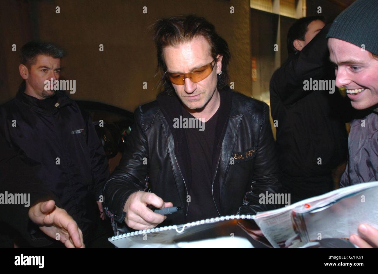 Singer Bono from Irish rock band U2, signs autographs for fans outside ...