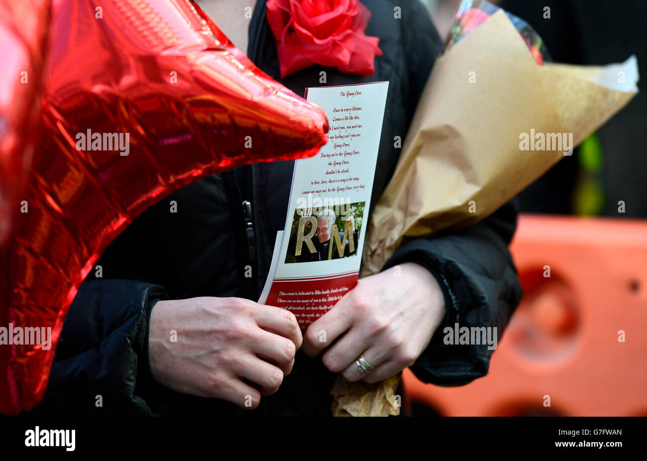 A fans holds a memorial leaflet as a bench celebrating the life Rik ...