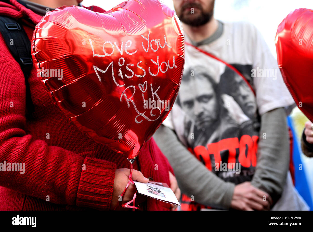 A fans holds a balloon as a bench celebrating the life Rik Mayall is ...