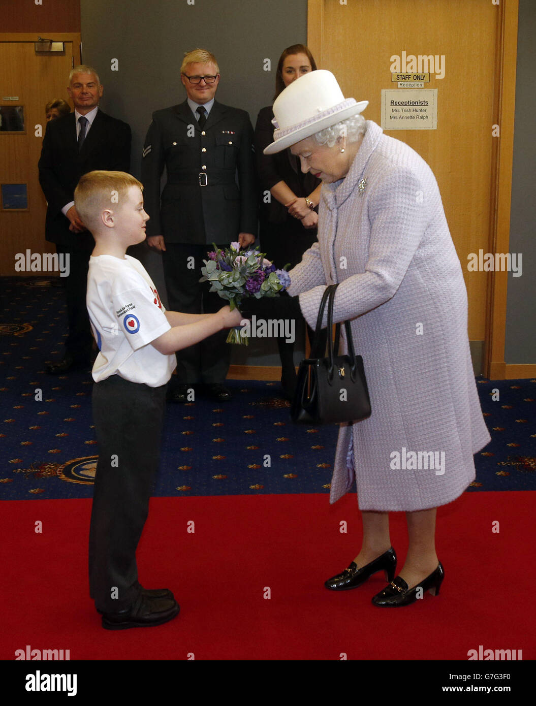 Queen Elizabeth II is presented with a posy of flowers by eight-year ...