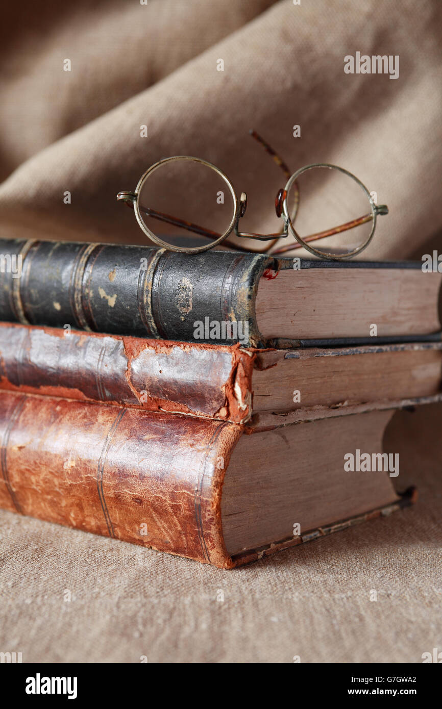 Vintage still life with stack of old books on canvas background Stock ...