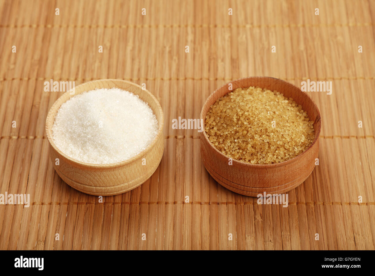 Choice, selection of two sugars in small full wooden bowls on bamboo ...