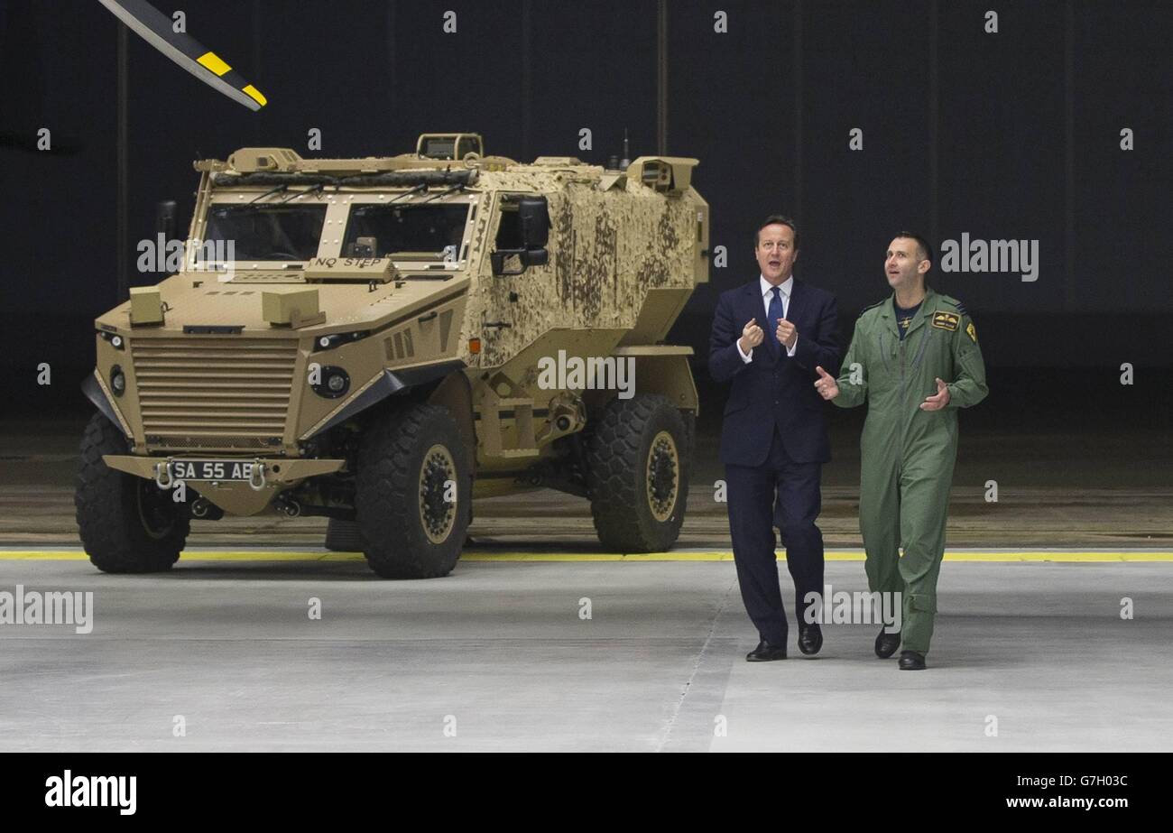 Prime Minister David Cameron walks in front of an armoured personnel ...