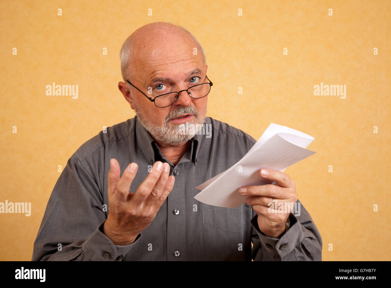 Elderly man, 59, holding a letter, bill, questioning look Stock Photo ...