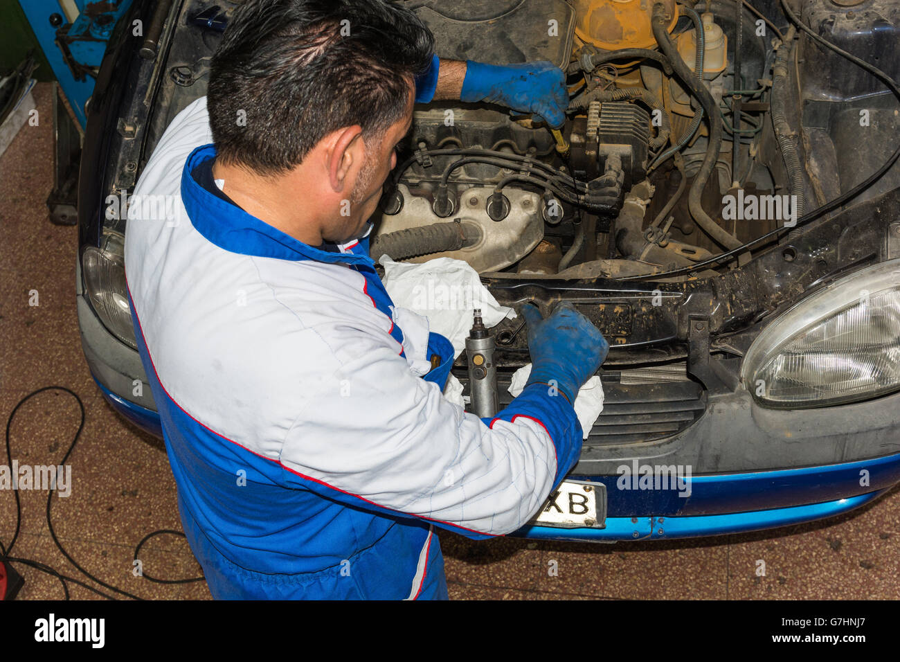 Automotive specialist adjusting an engine in his garage, closeup of an ...
