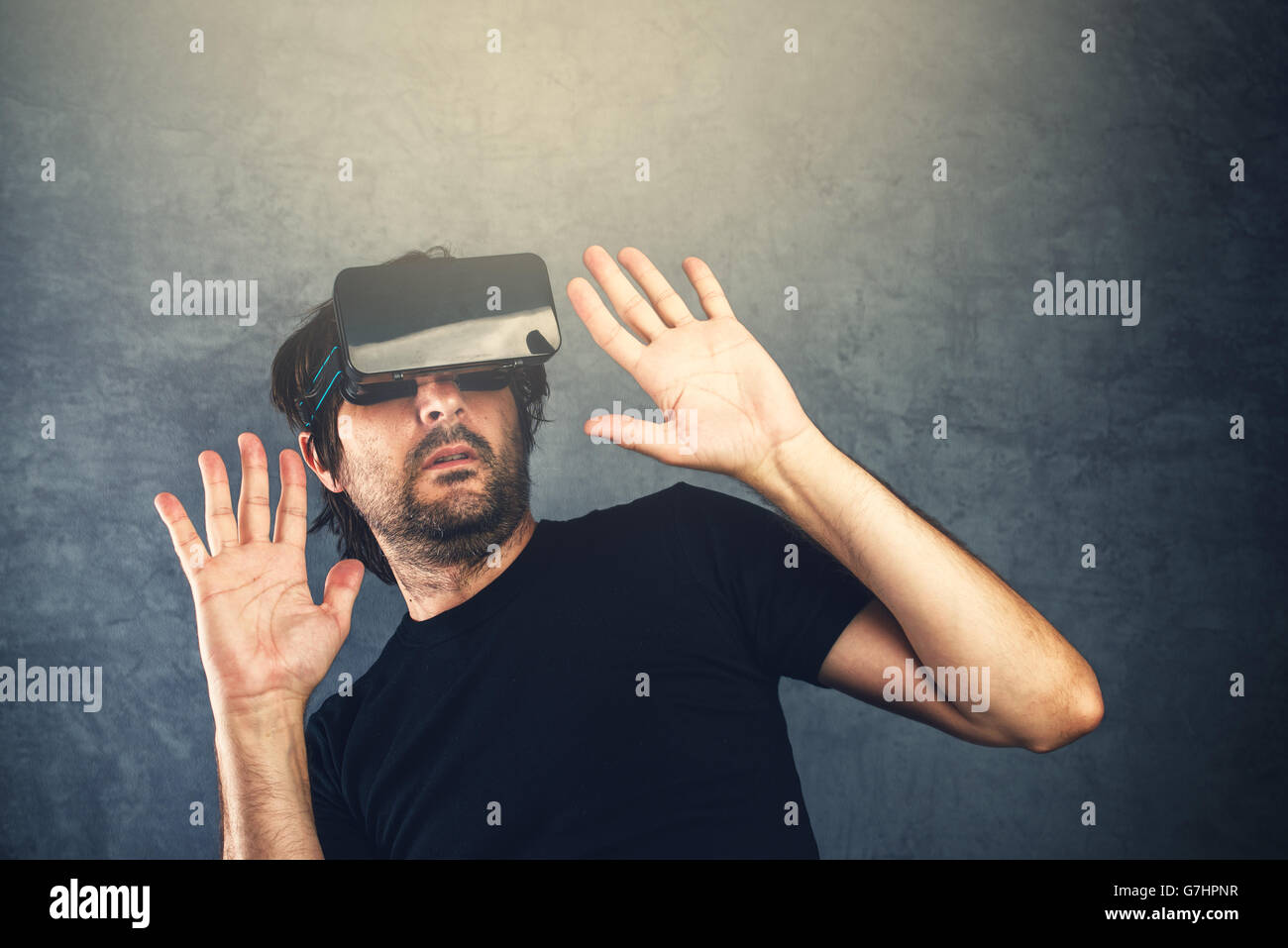 Scared adult man wearing virtual reality goggles and enjoying in scary ...