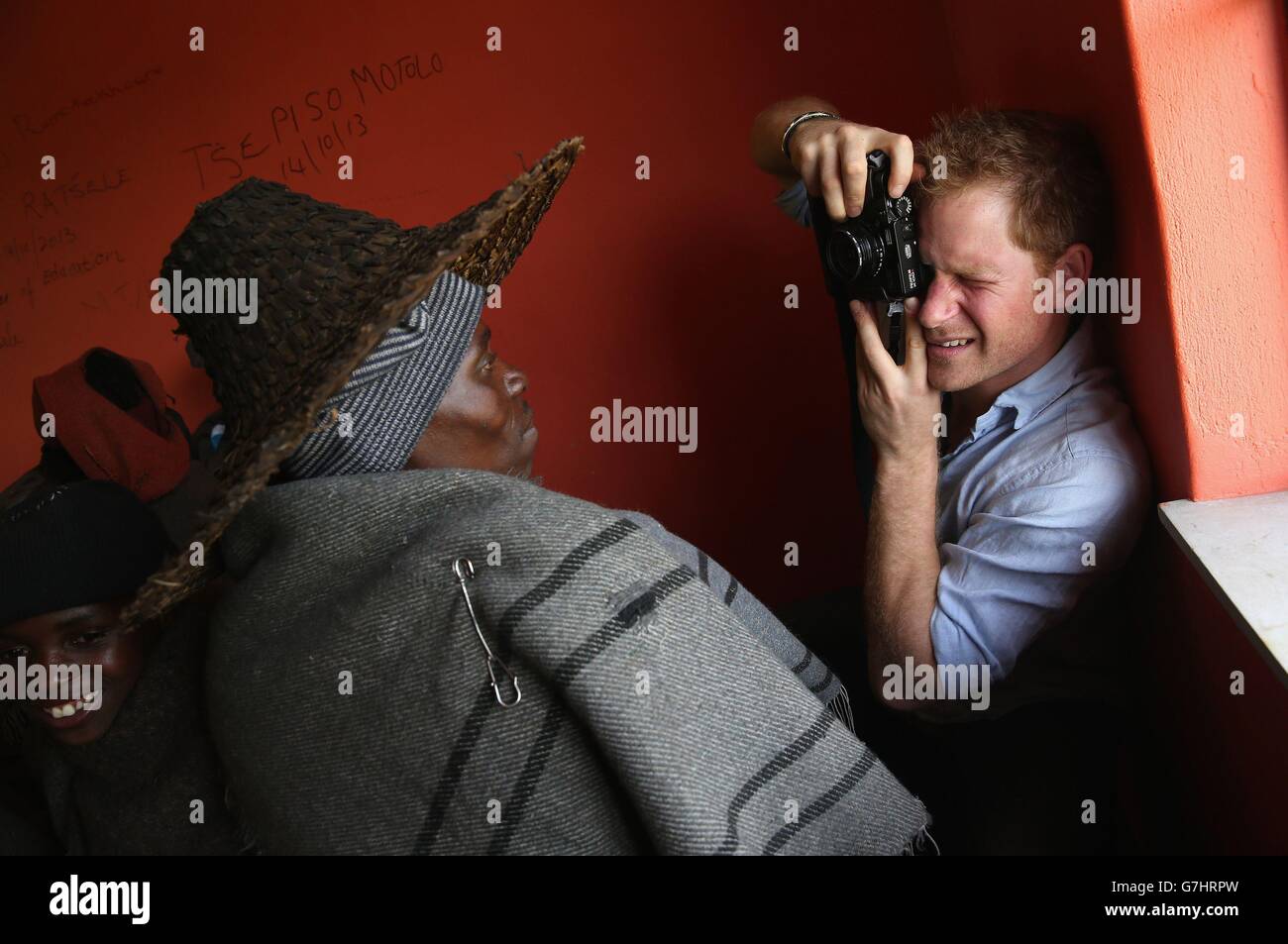 Prince Harry takes a photograph on a Fuji X100s Camera during a visit ...