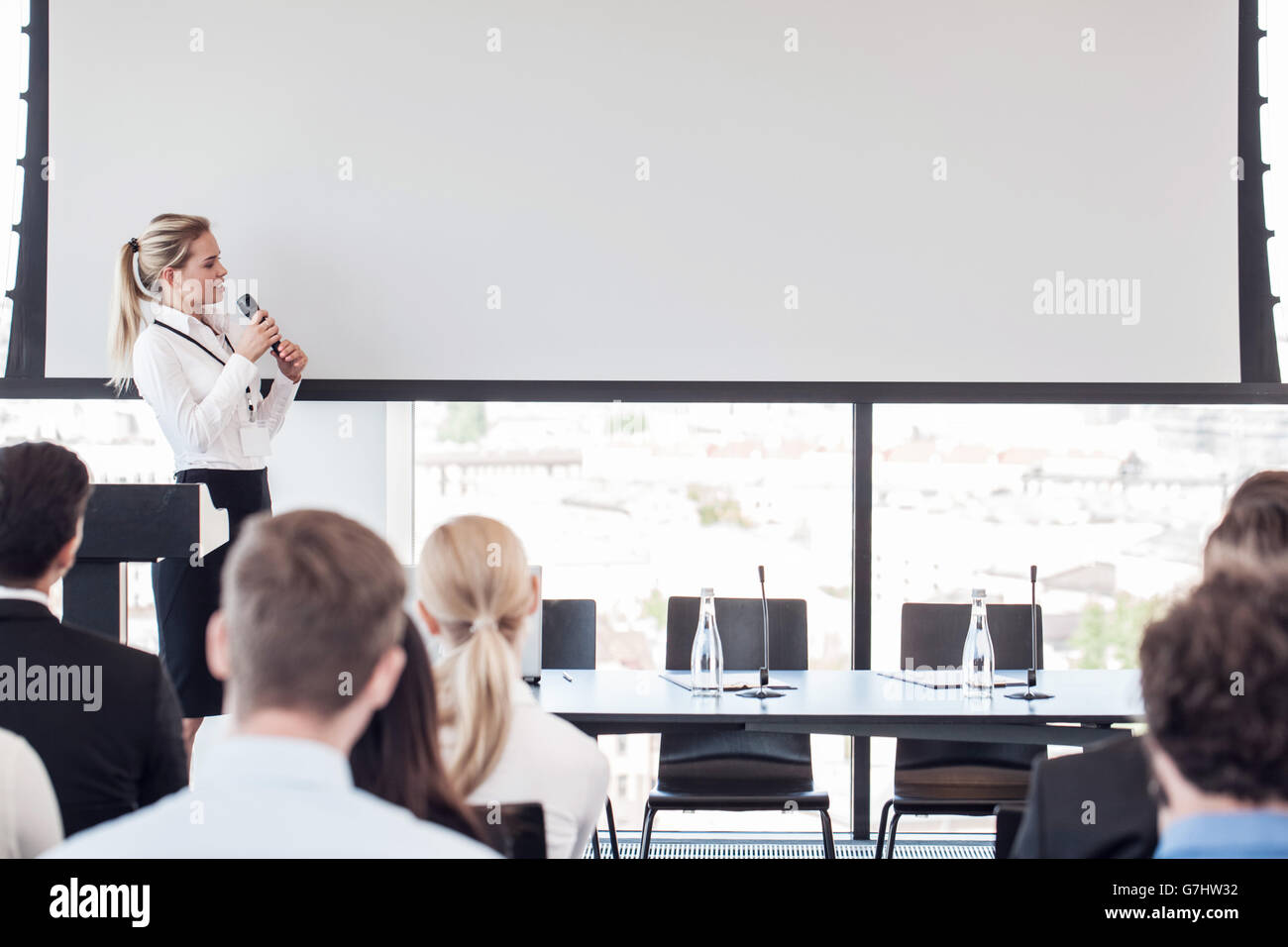Business woman speaking at presentation in microphone in office Stock ...