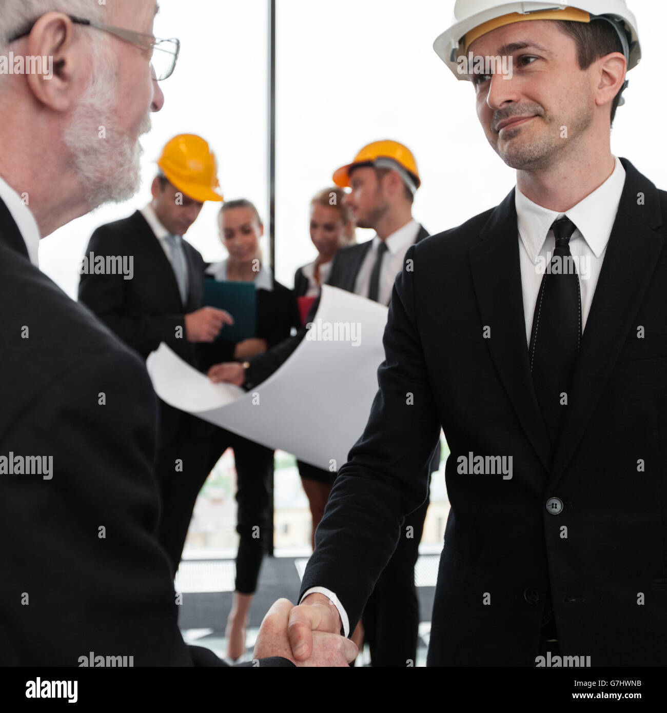 Handshake of architect and investor, business team with blueprint on ...