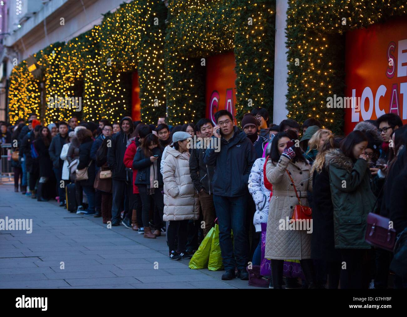 Shoppers queue outside Selfridges on Oxford Street, London, as they ...
