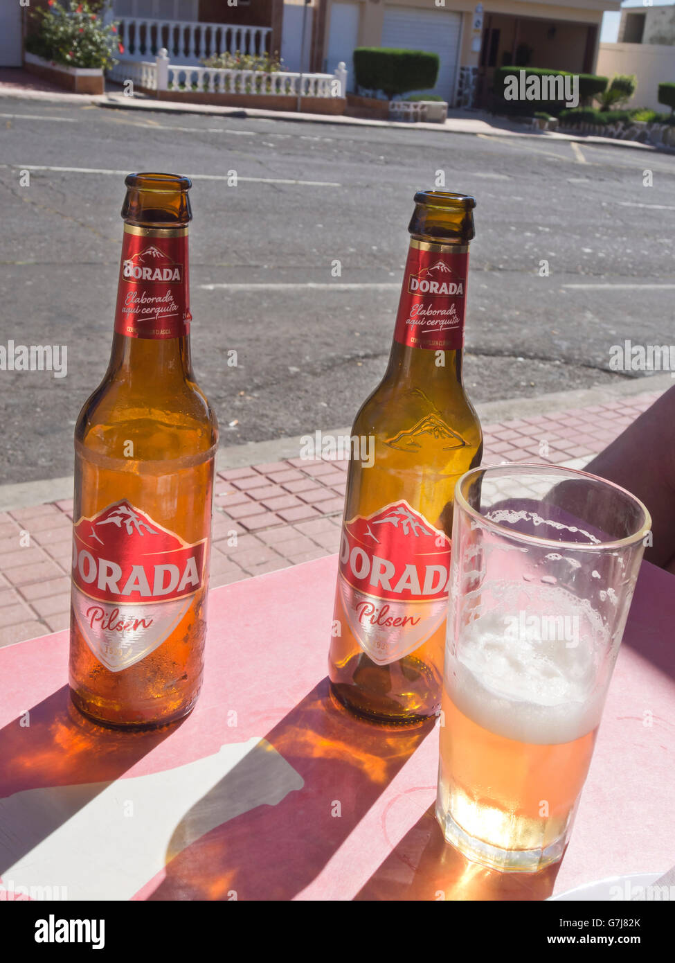 Sun shining through two empty brown Dorada bottles and an half emptied ...