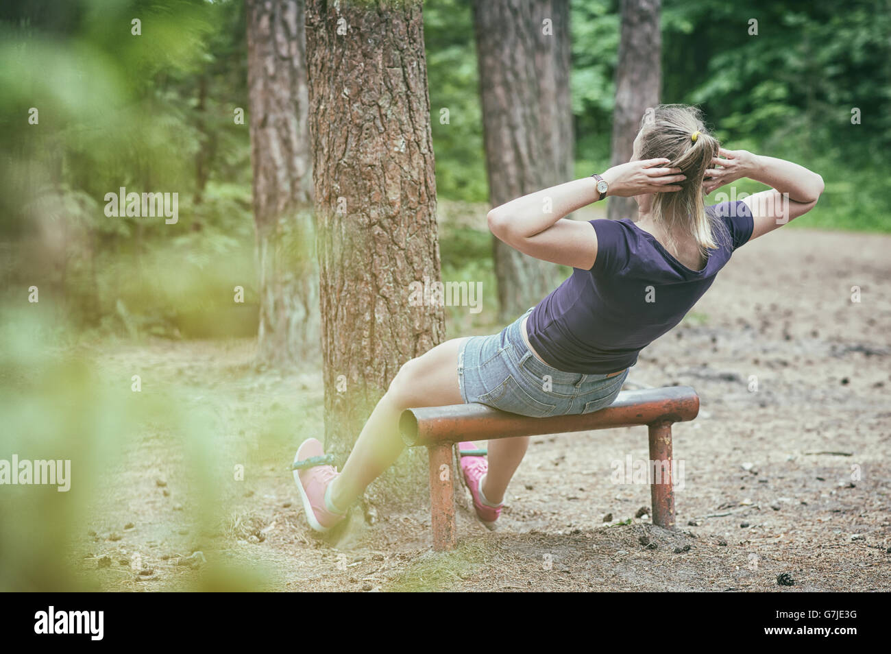 Woman doing abs workout in the forest Stock Photo - Alamy