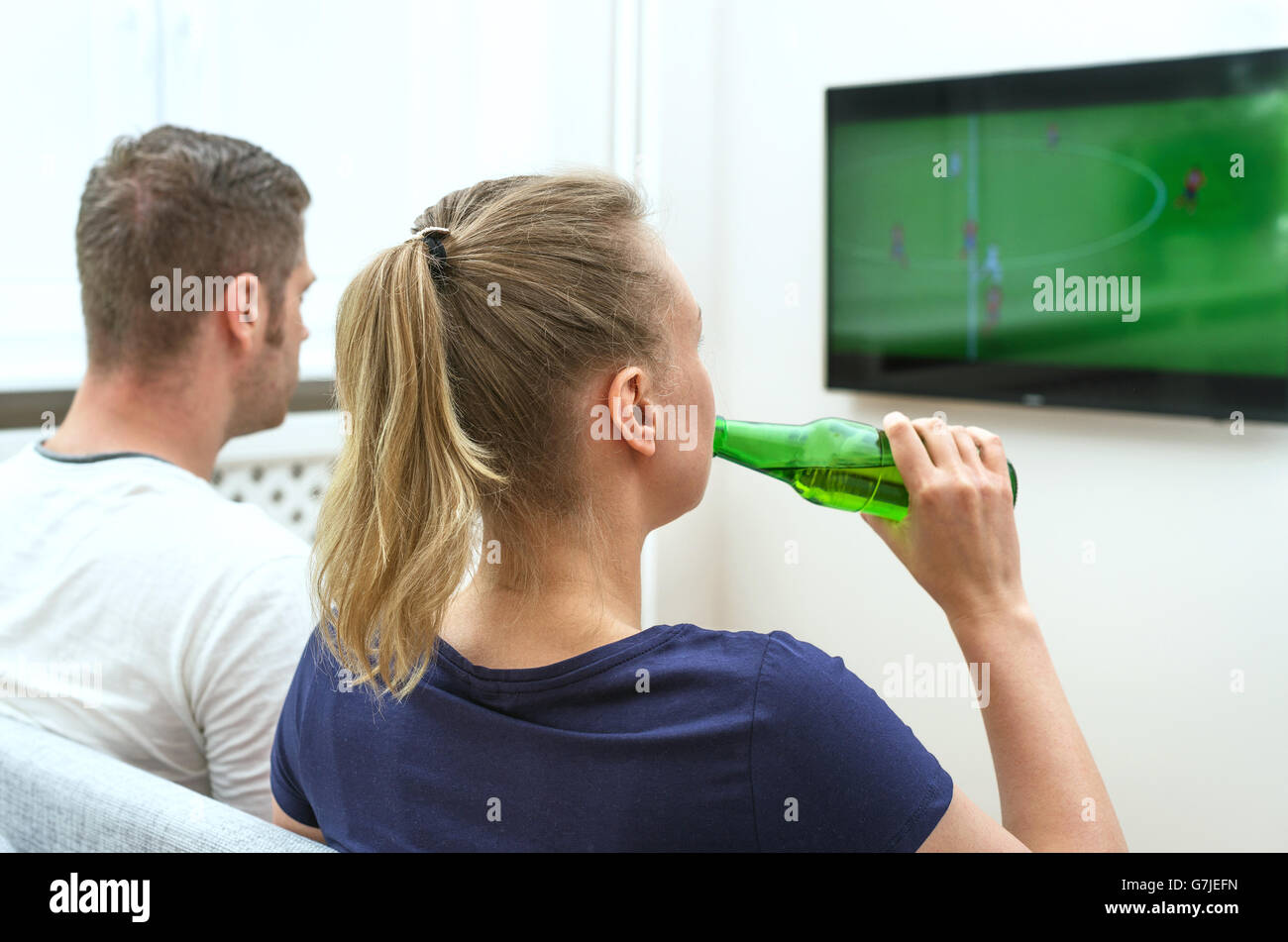 Couple watching football match on tv Stock Photo - Alamy