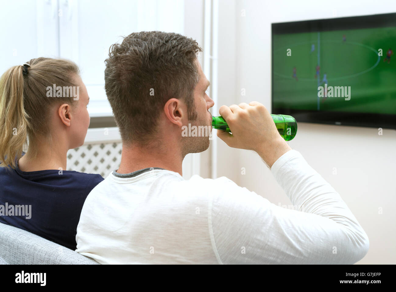 Couple watching football match on tv Stock Photo - Alamy