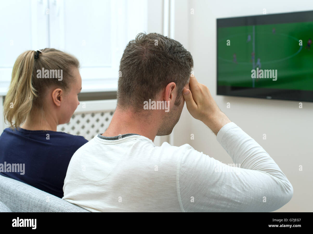 Couple watching football match on tv Stock Photo - Alamy