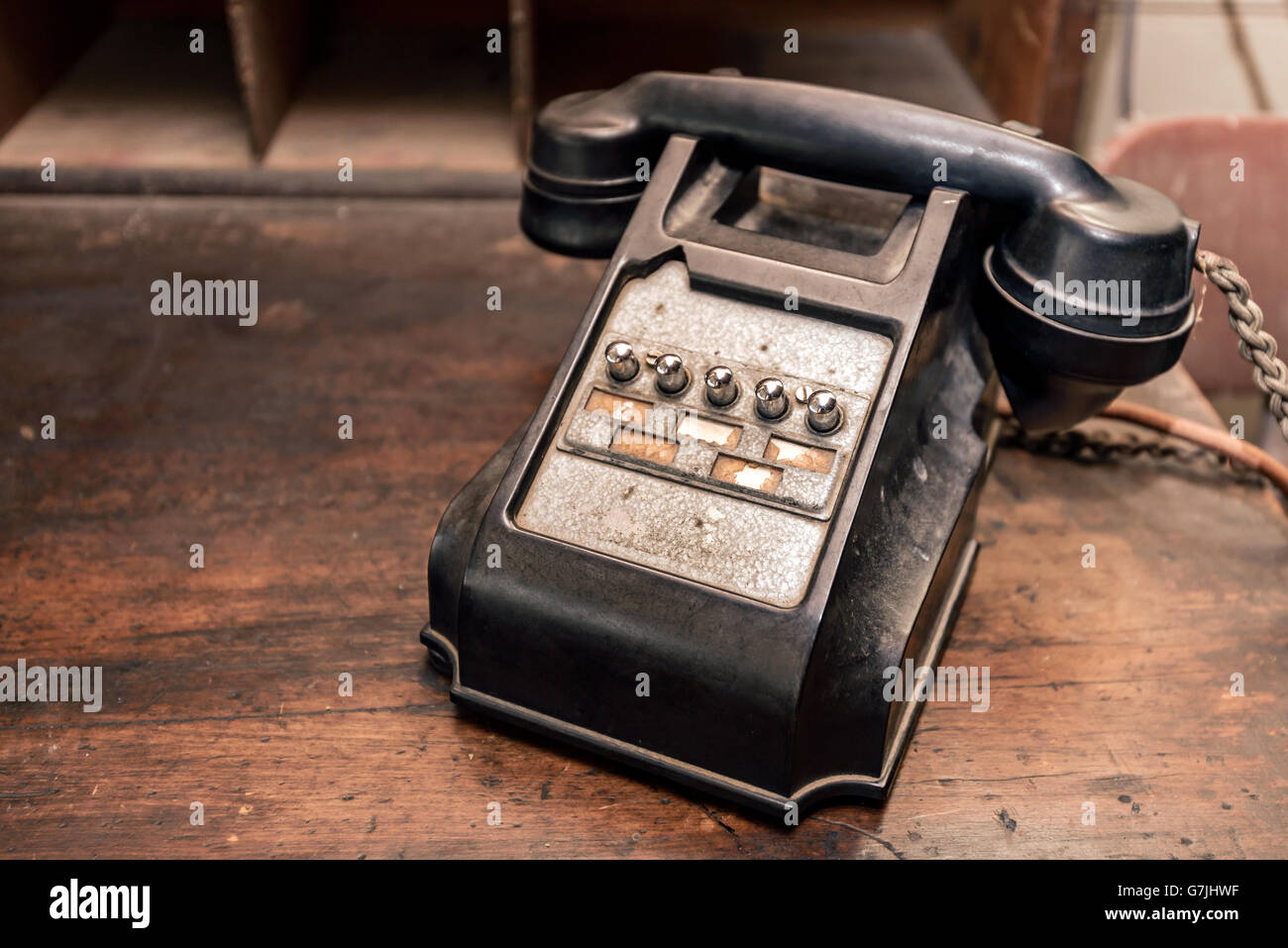 Old black dusty telephone with buttons on desk Stock Photo - Alamy