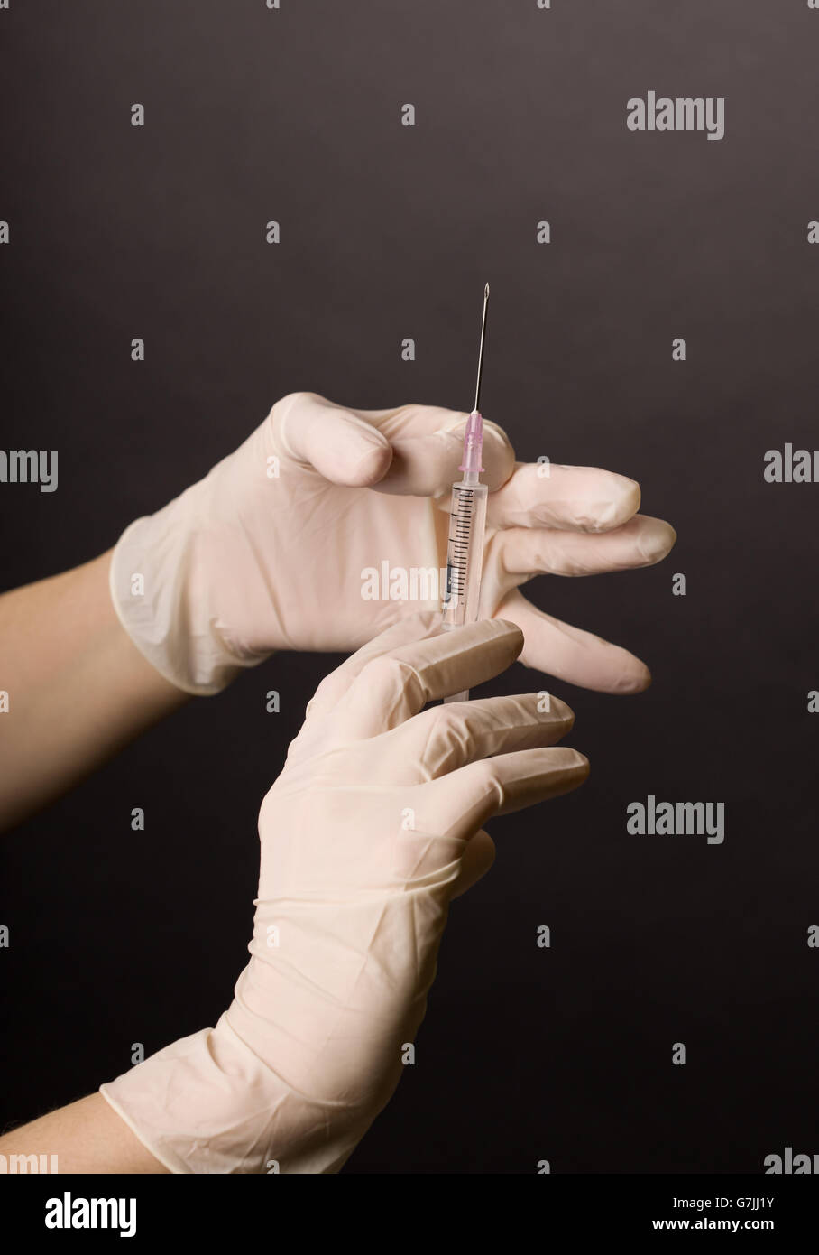 Female hands in latex gloves. Flicking syringe. Doctor or nurse ...
