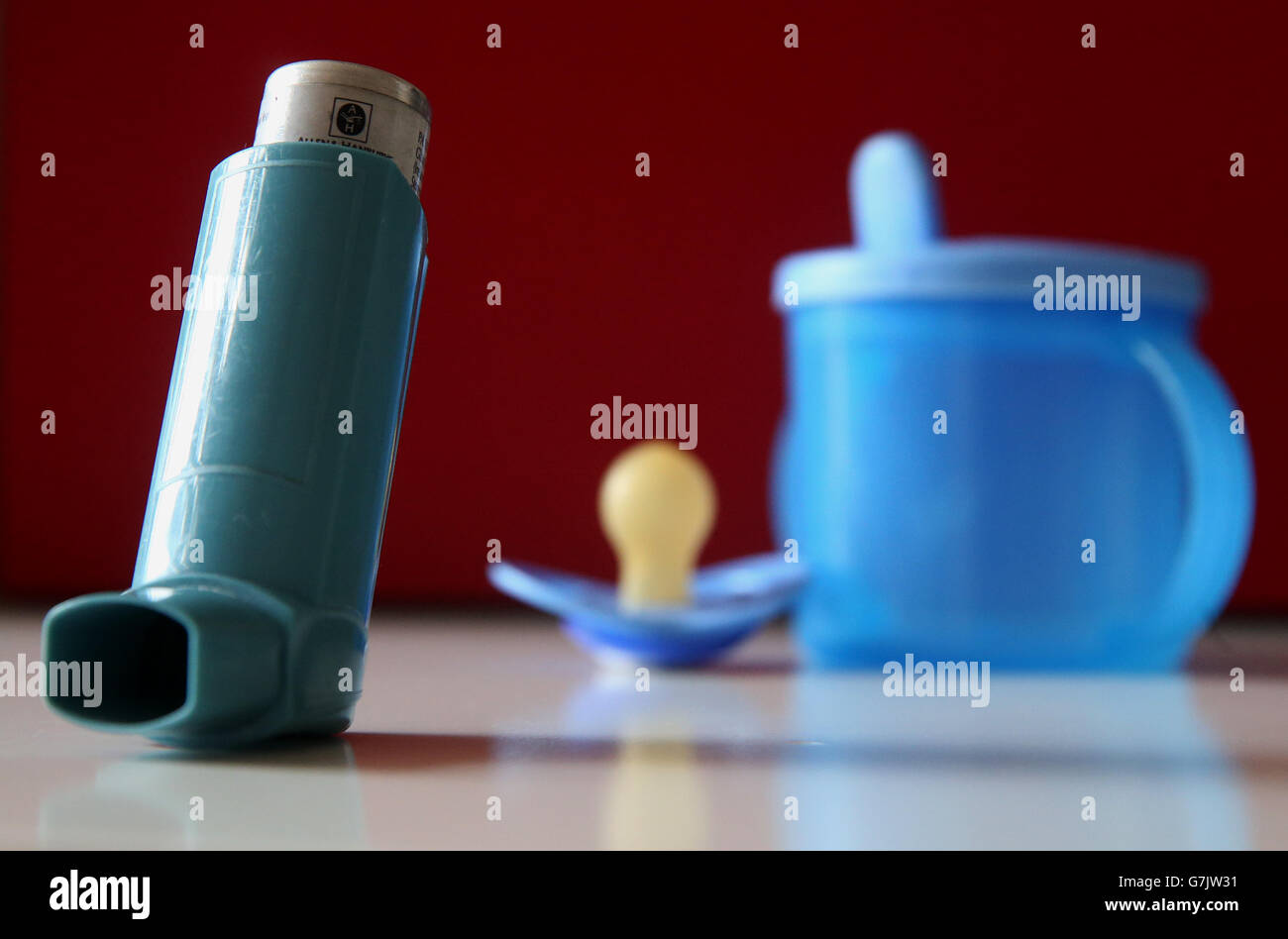An inhaler used for treating asthma sits beside a child's soother and ...