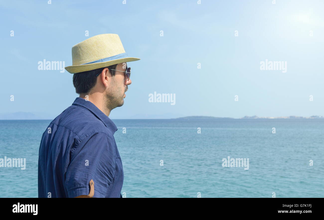 Man in blue shirt looking at the horizon at seaside Stock Photo - Alamy