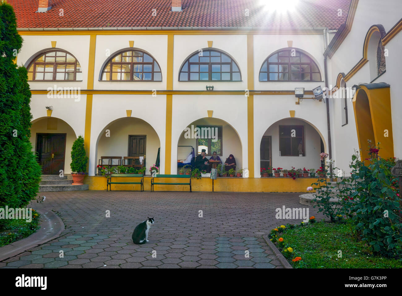Two priests and a nun in the courtyard at Privina Glava Monastery ...