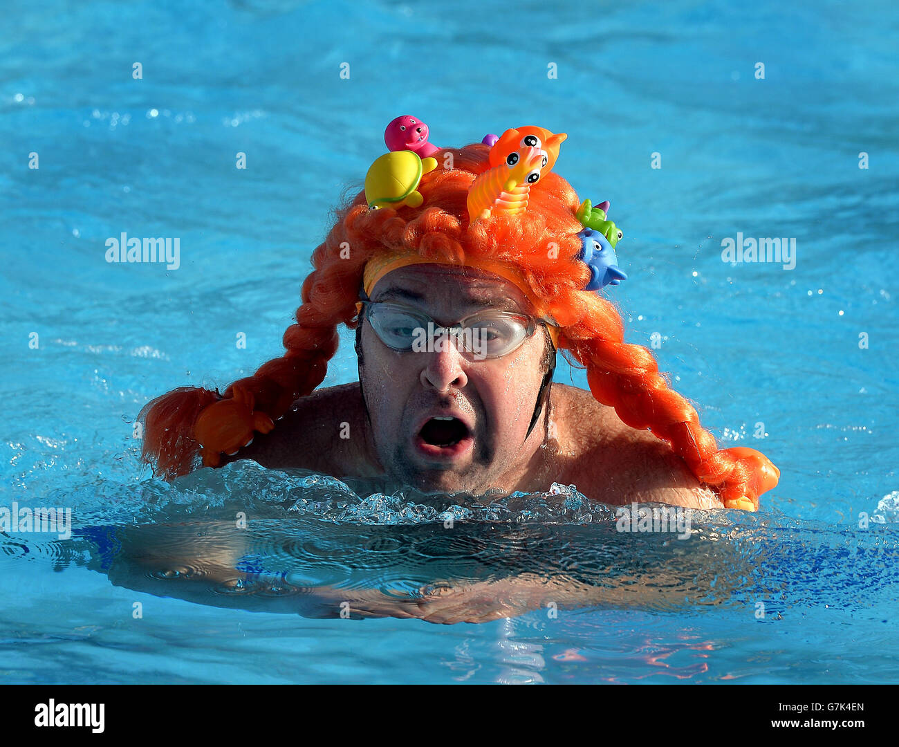 A competitor takes part in the fancy Hat swimming race during the 6th ...