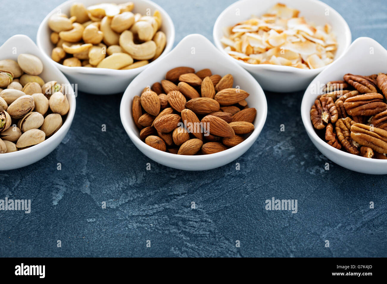 Variety of nuts in small white bowls healthy snacks Stock Photo - Alamy