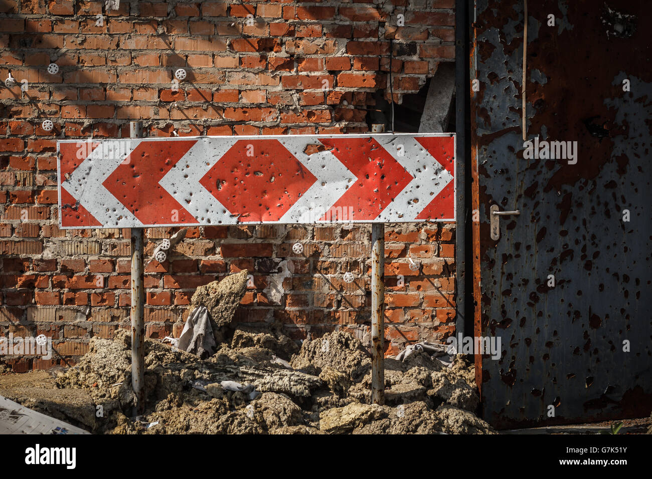Flecked with shrapnel brick wall, door and sign Stock Photo - Alamy