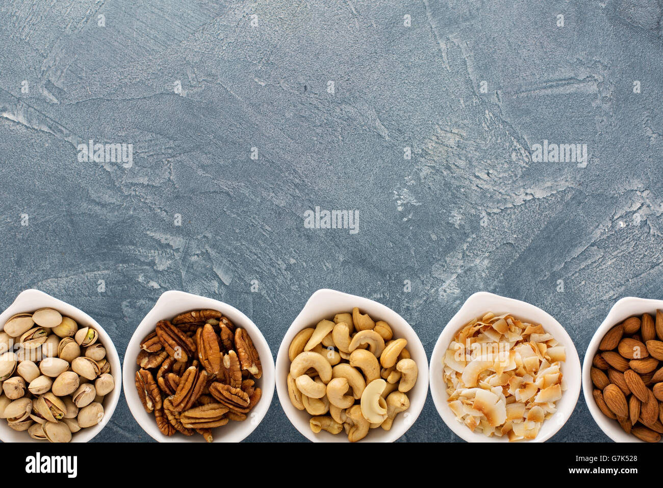 Variety of nuts in small white bowls healthy snacks Stock Photo - Alamy