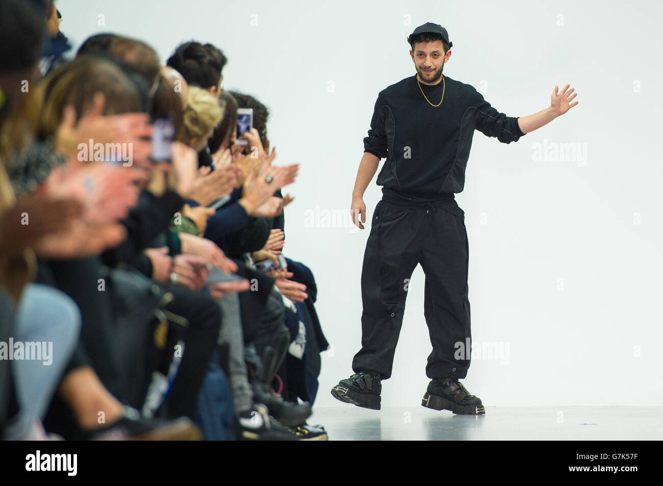 Designer Nasir Mazhar waves to the audience following the Nasir Mazhar ...
