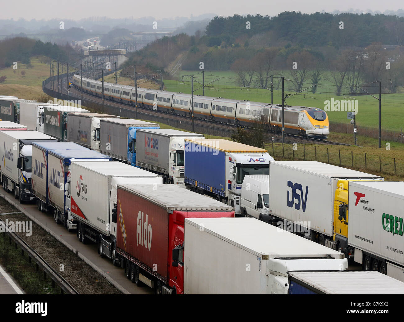 A Eurostar train passes lorries parked in Operation Stack on the M20 ...