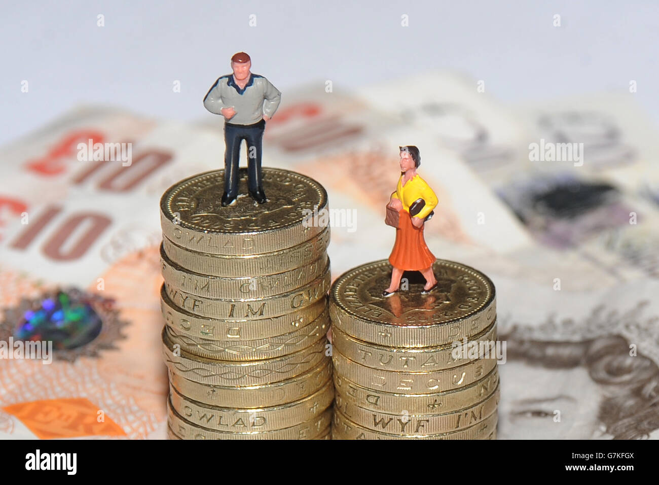 Plastic models of man woman stand on pile of coins hi-res stock ...