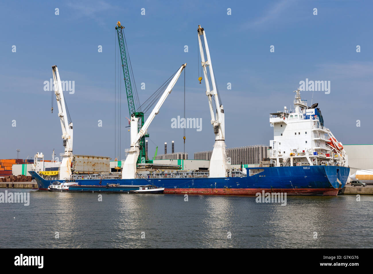 Harbor of Antwerp with cargo ships moored at quay with big cranes ...