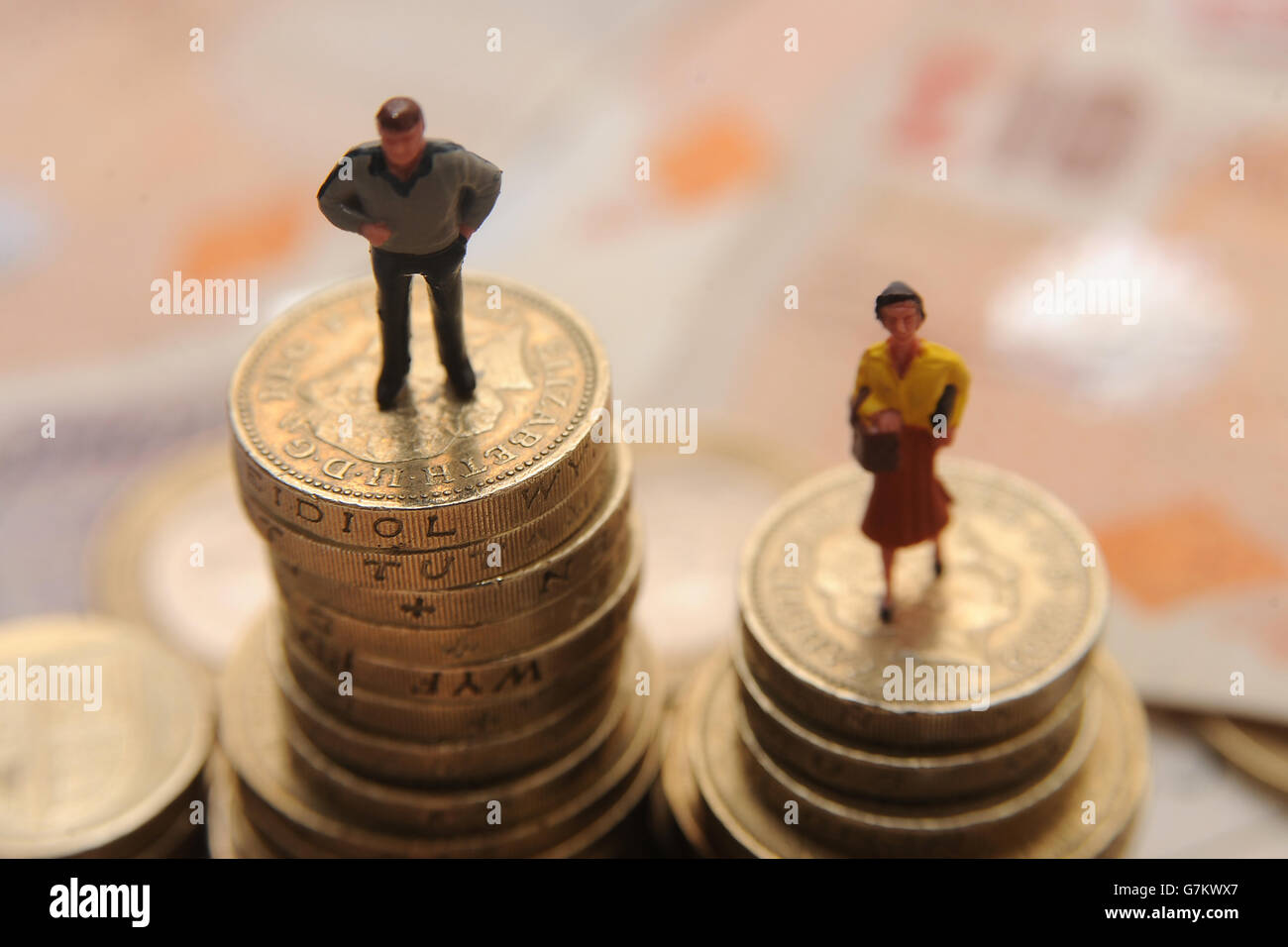 Plastic models of man woman stand on pile of coins hi-res stock ...