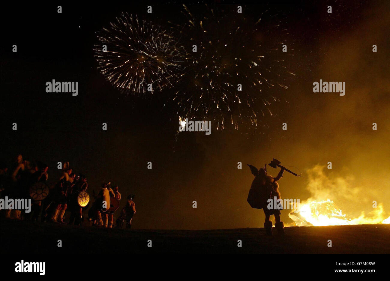 A group of Vikings watch the fireworks after they set light to a Viking ...